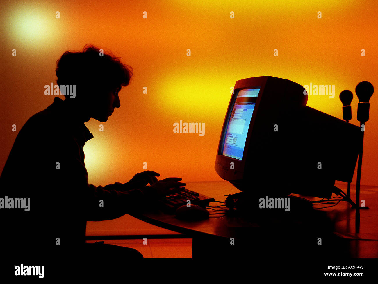 Young man sitting at a computer Stock Photo - Alamy
