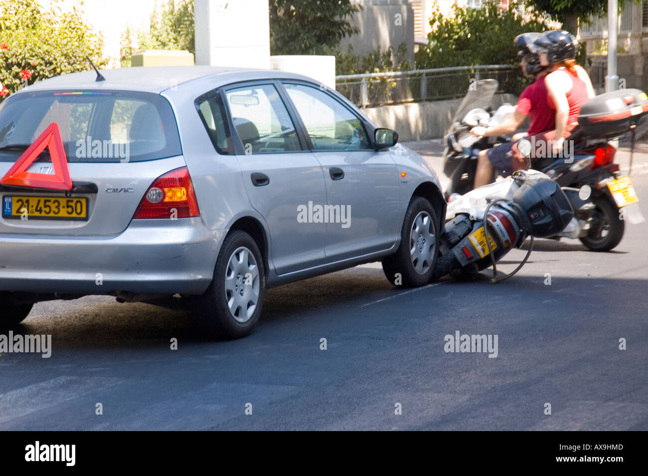 A motor collision between a car and a motorbike at a city intersection ...