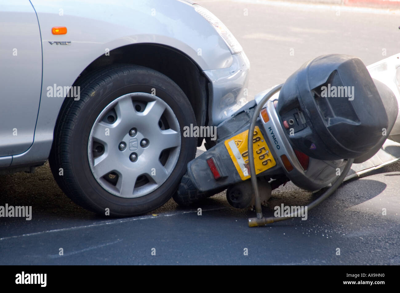 A motor collision between a car and a motorbike at a city intersection ...