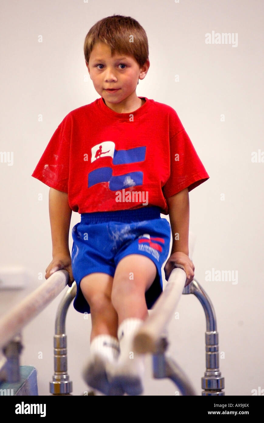 Young boy performs on parallel bars during demonstration gymnastics ...