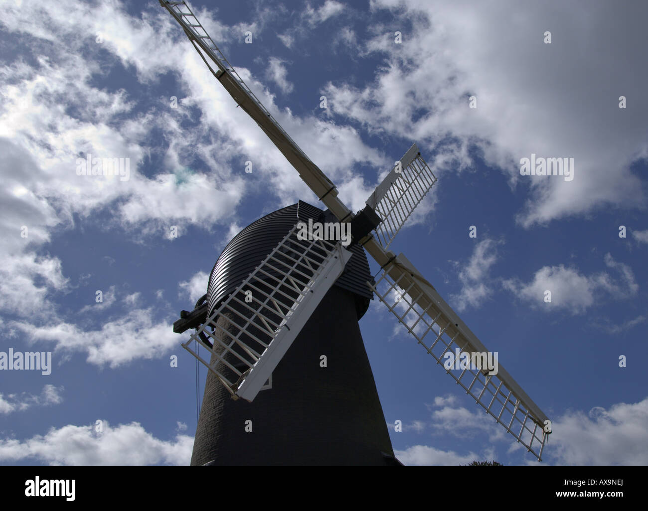 A windmill against a blue sky with white clouds Stock Photo - Alamy