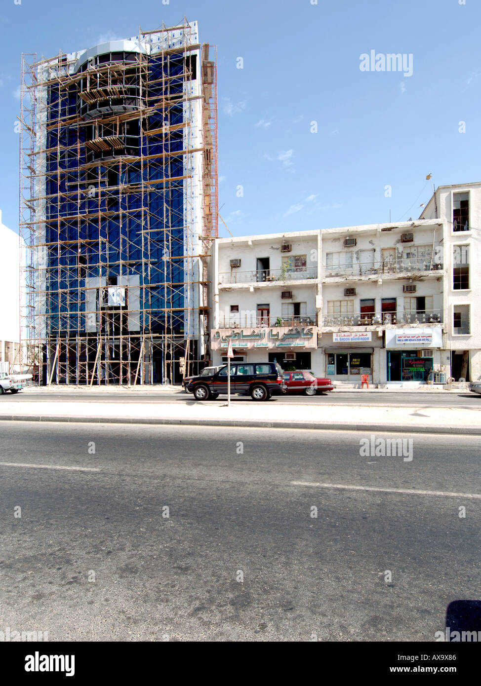 A new, modern building under construction alongside a run-down building ...