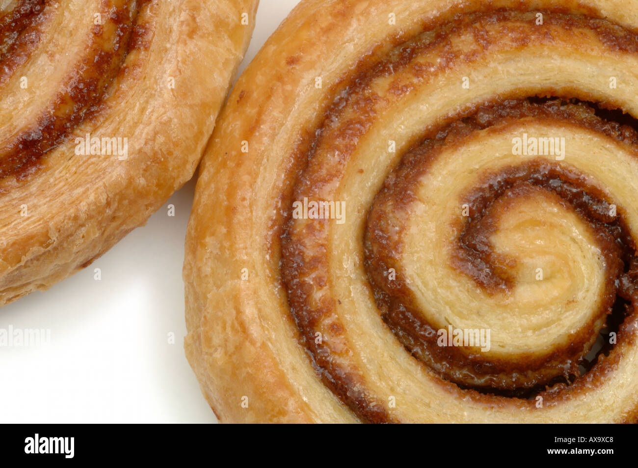 2 two Danish cinnamon whirl pastry closeup detail on white background ...
