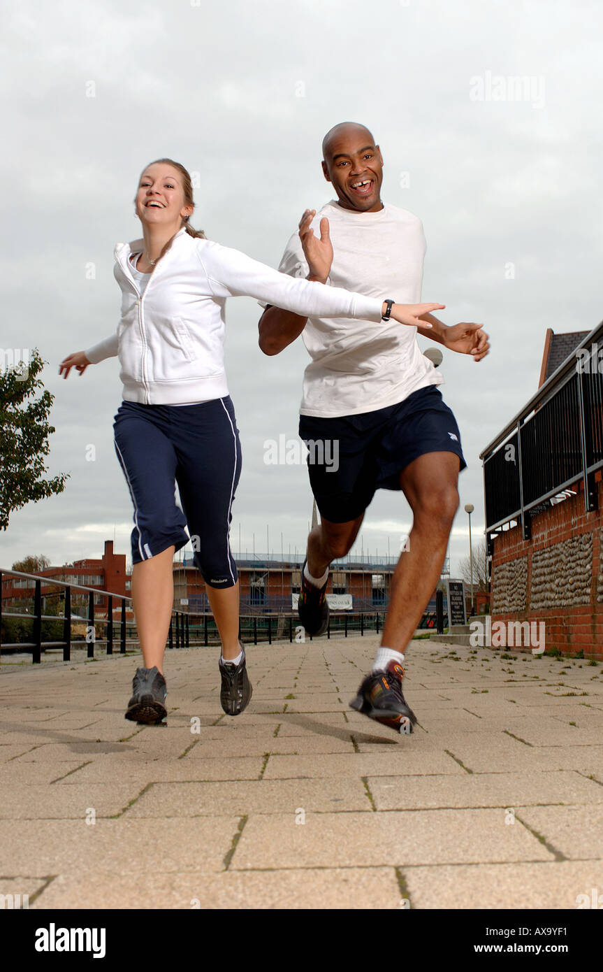 Mixed Race Couple Running Along Path Stock Photo - Alamy