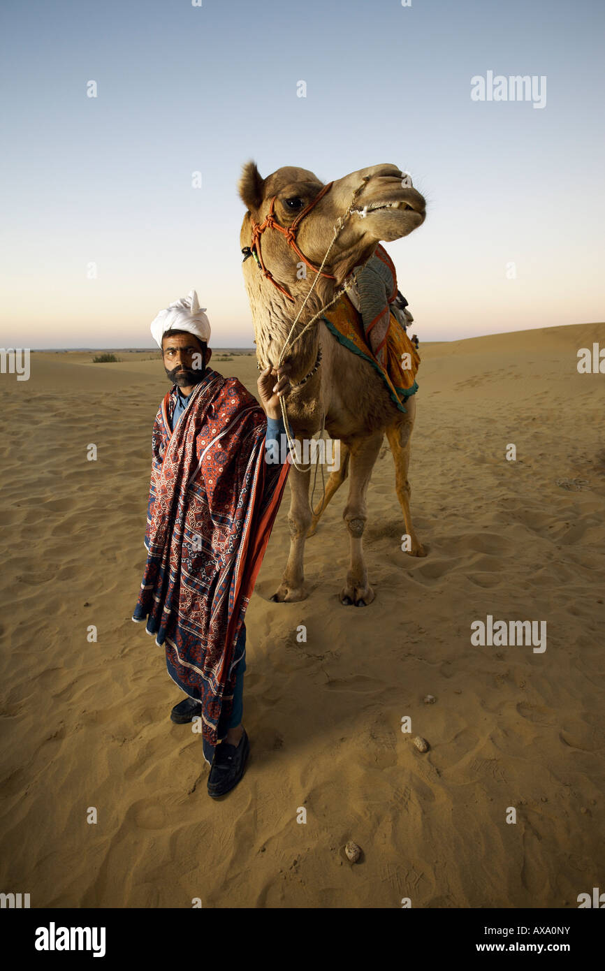 A wide-angle image of a camel guide standing with his camel in the ...