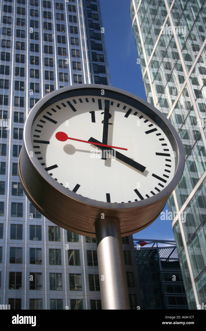 Circular white clock face showing 4pm with towering offices and blue ...