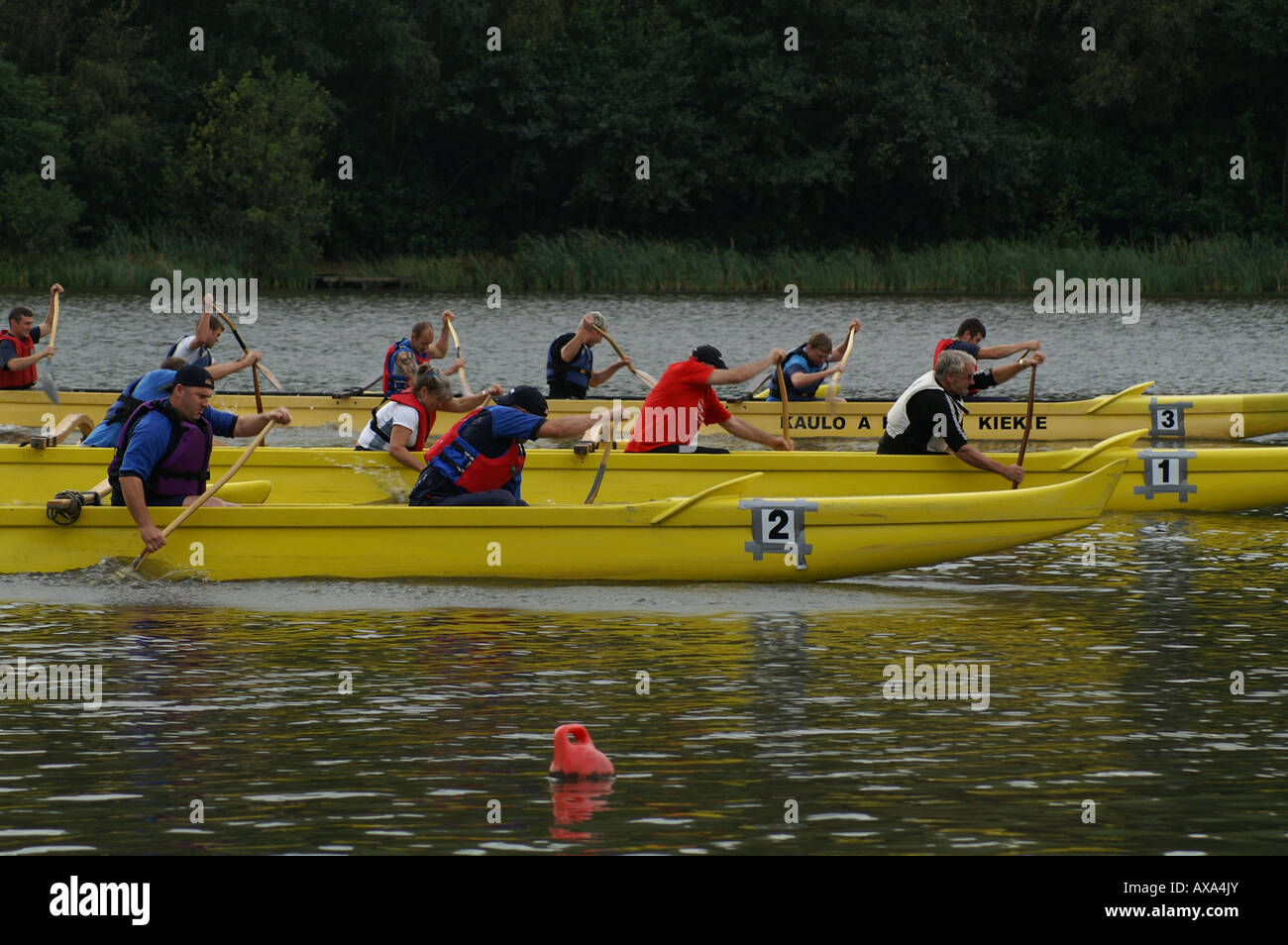 Three Hawaiian outrigger canoes racing across a lake Stock Photo - Alamy