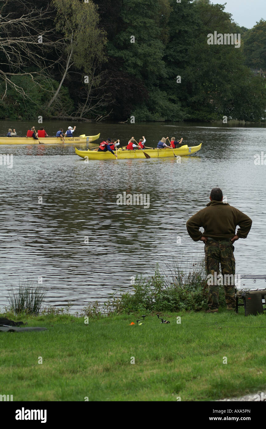 Two Hawaiian outrigger canoes racing across a lake Stock Photo - Alamy