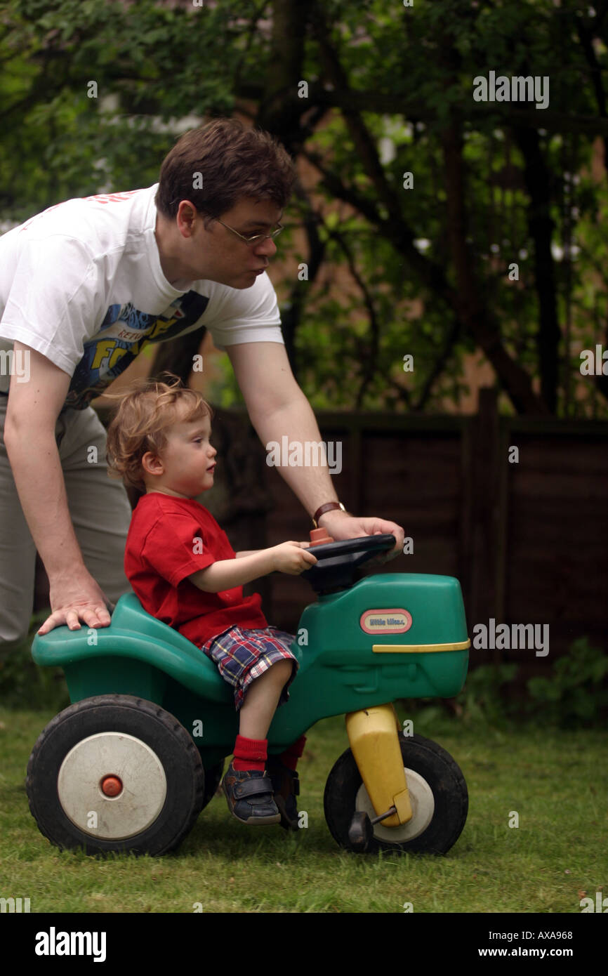 Lewis aged two being pushed on a plastic tractor by Martin Stock Photo ...