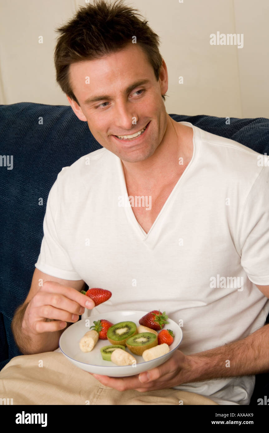 man eating a bowl of fruit Stock Photo - Alamy