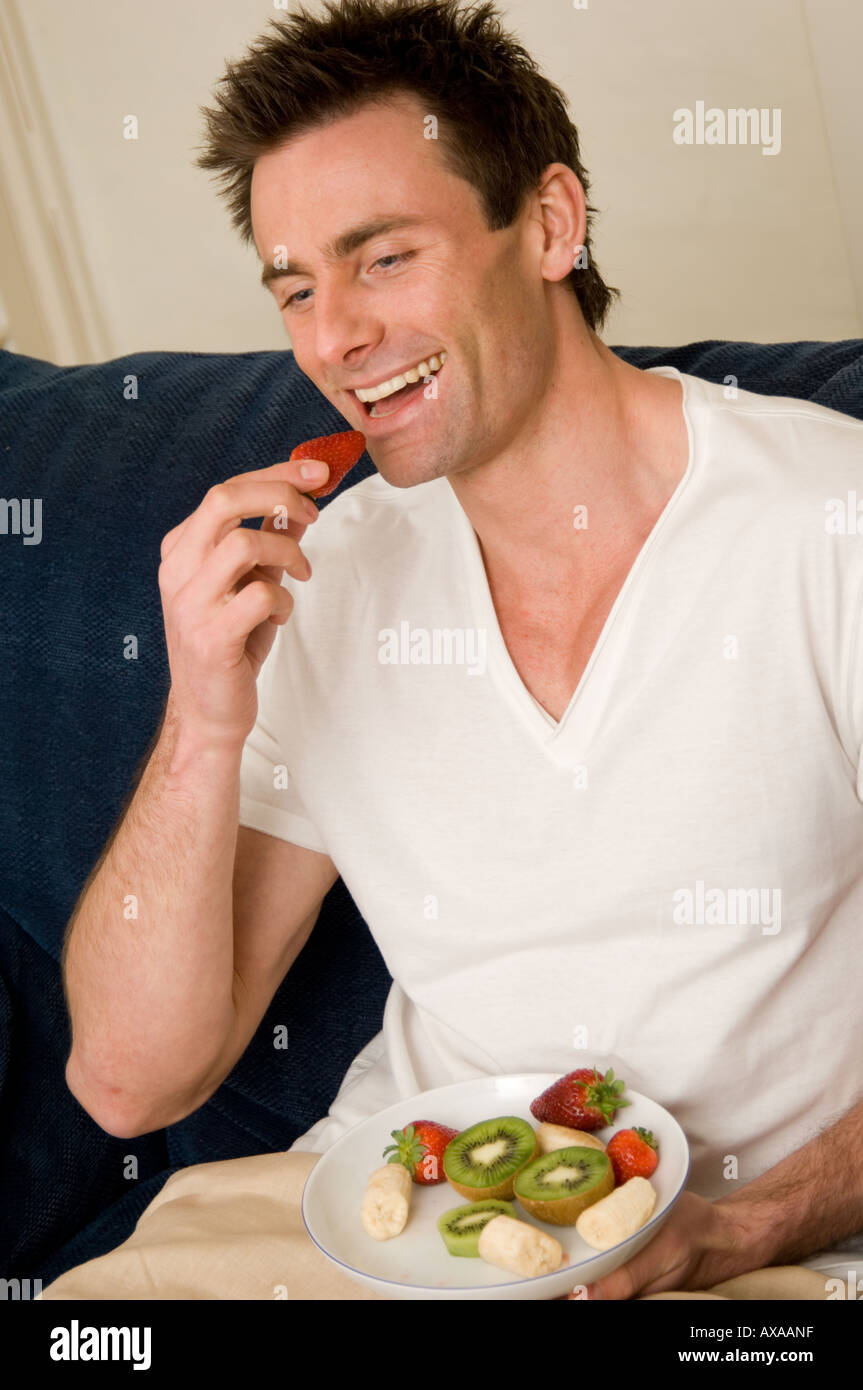 man eating a bowl of fruit Stock Photo - Alamy