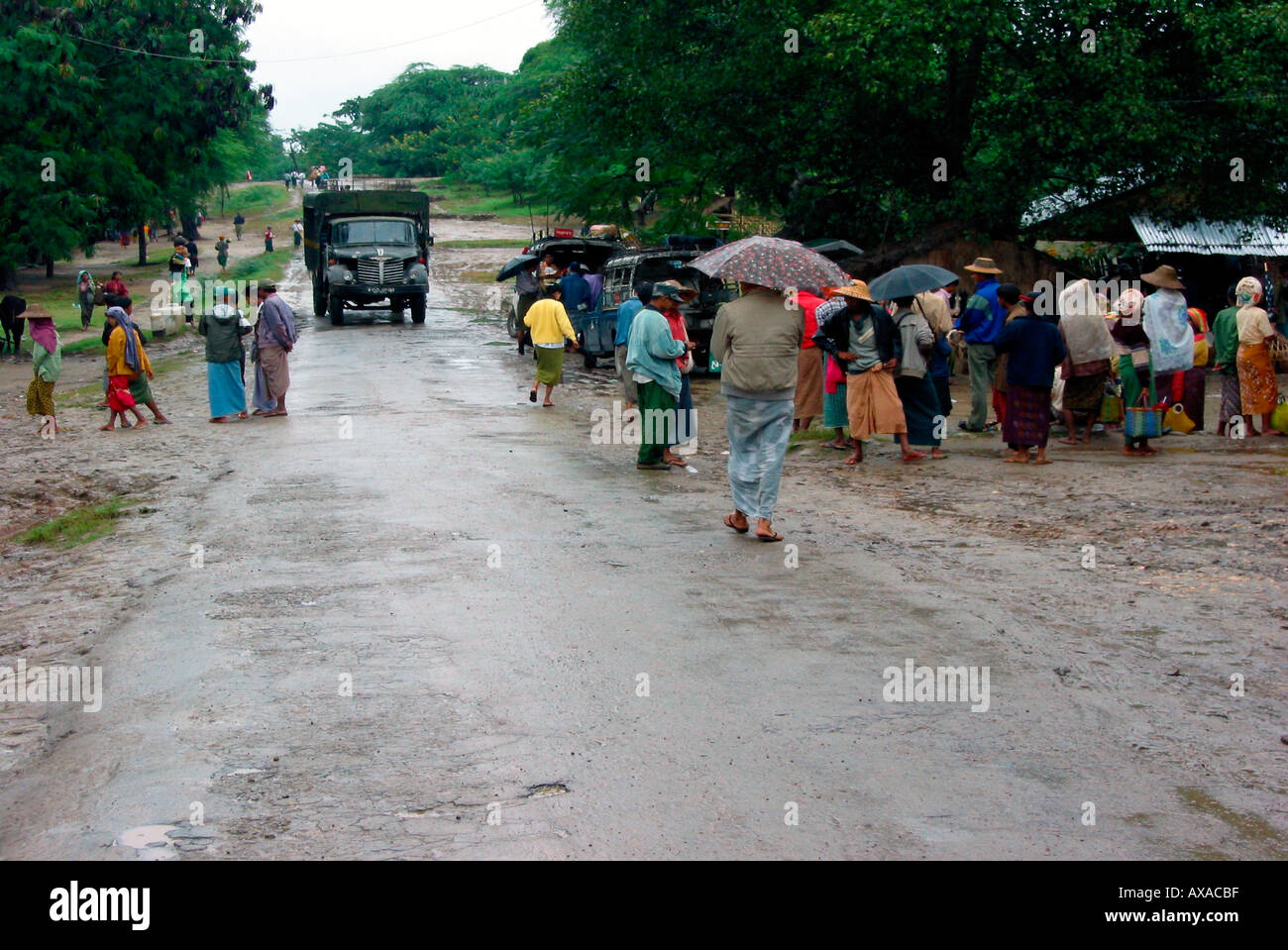 Villagers go to market in the rain along Road to Mandalay at Pyawbwe ...
