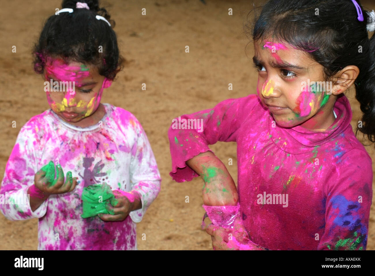 Two young Indian girls playing Holi at the Indian spring festival Holi ...