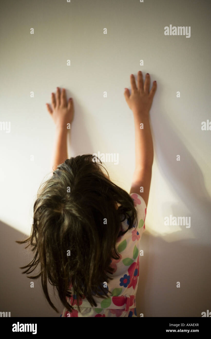Girl reaches up wall Stock Photo - Alamy