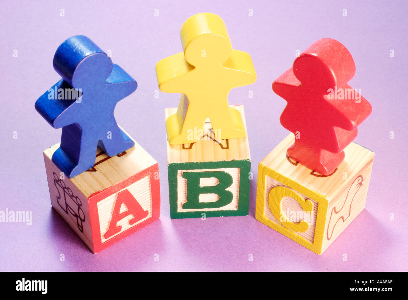 Wooden Children Figures Standing on Alphabet Blocks Stock Photo - Alamy