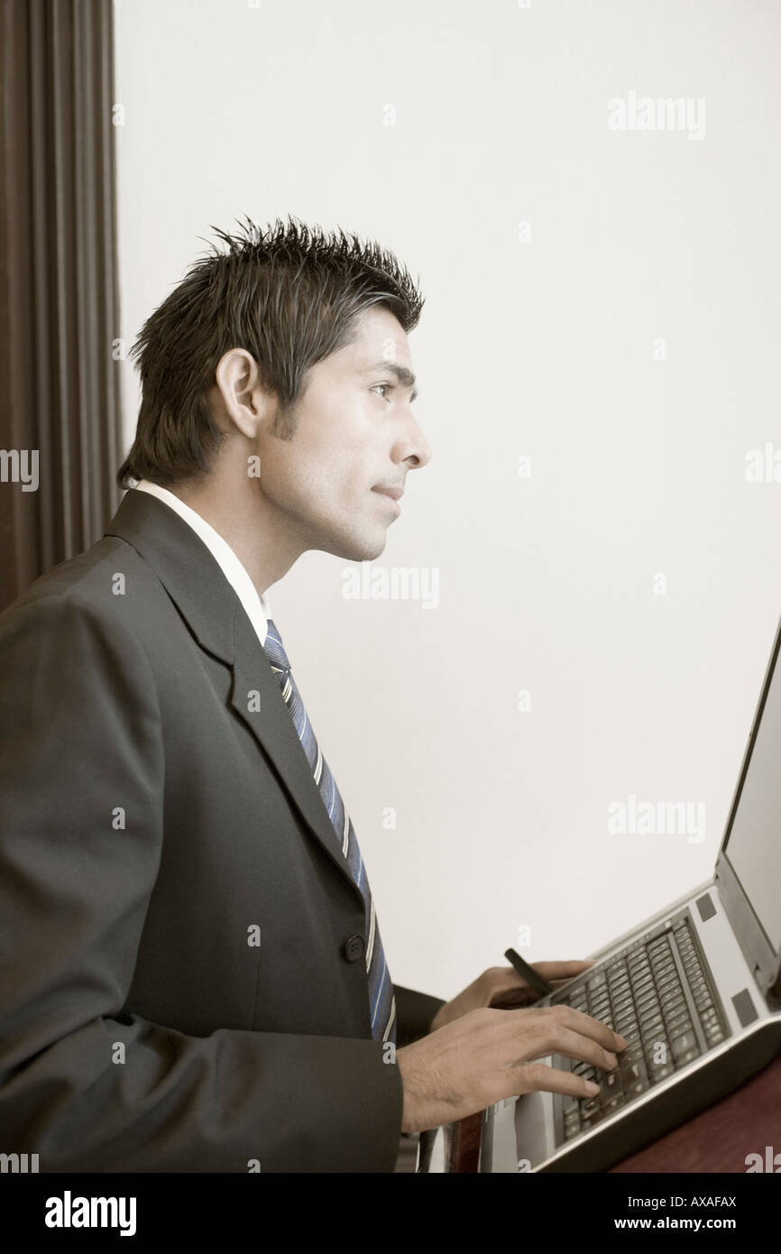 Side profile of a businessman using a laptop on a lectern Stock Photo ...