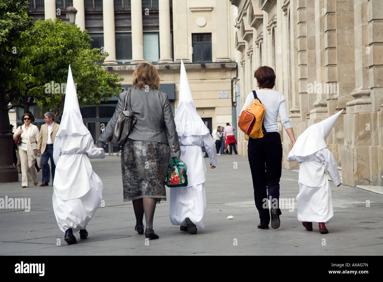 Two women leading young penitents to the church for a Holy Week ...