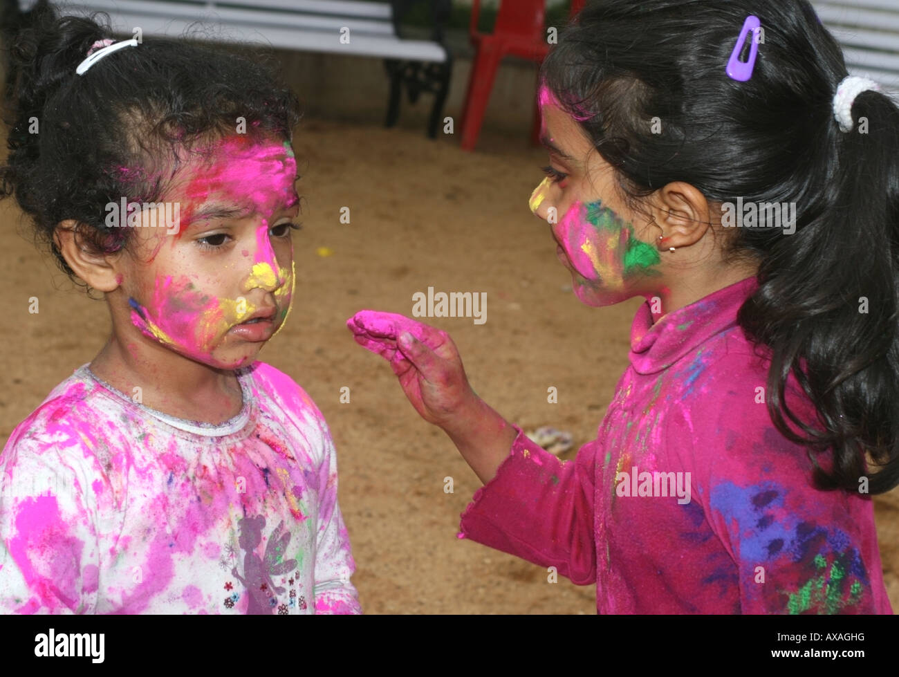 Two young Indian girls playing Holi at the Indian spring festival Holi ...
