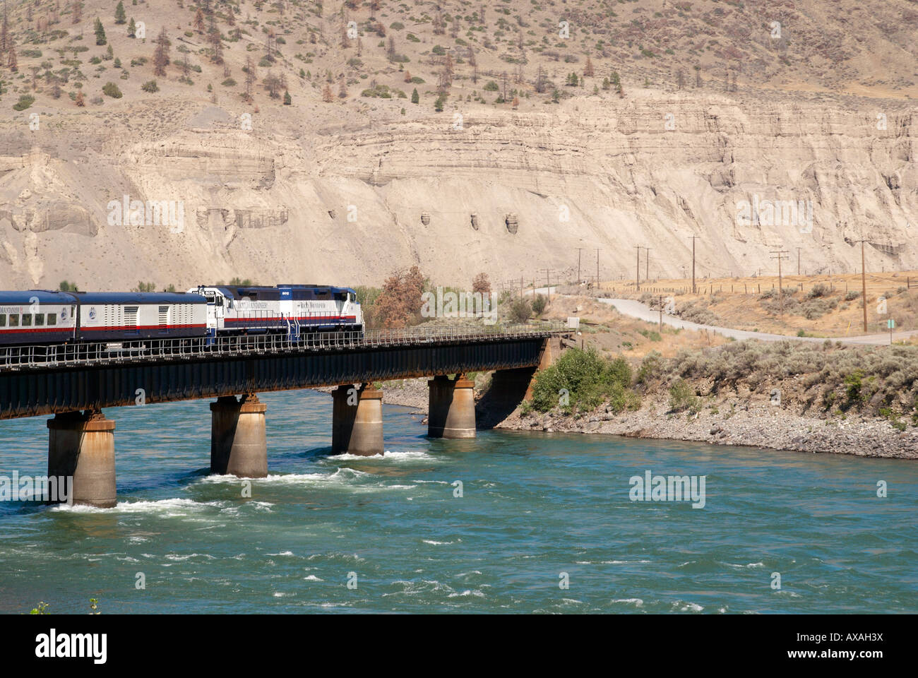 Rocky Mountaineer train crossing the Thompson River in semi-desert ...