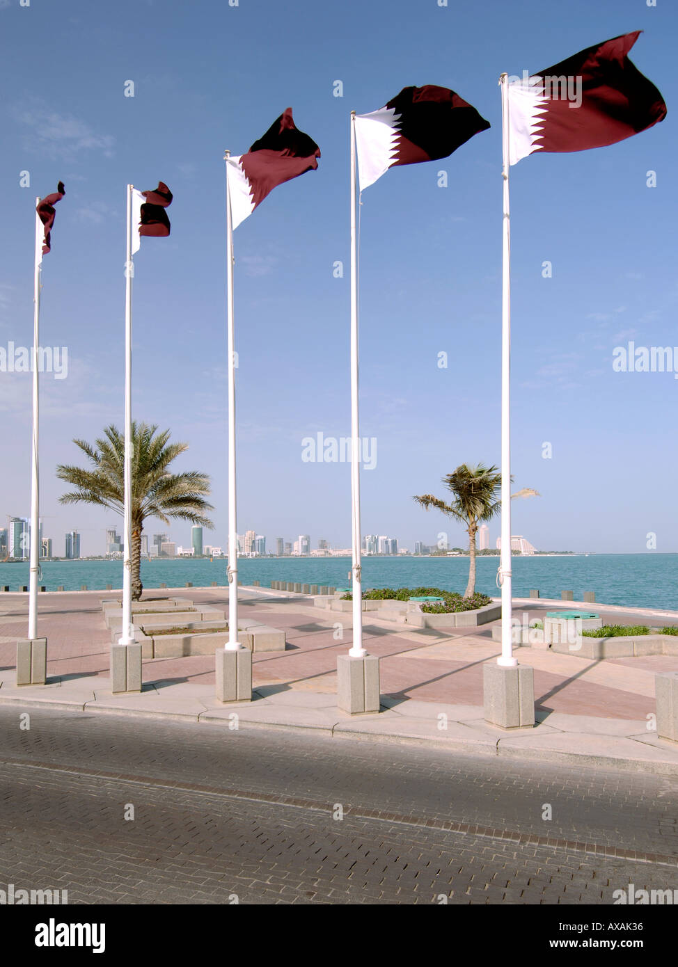 Qatari flags and the buildings along west bay on the Doha corniche in ...