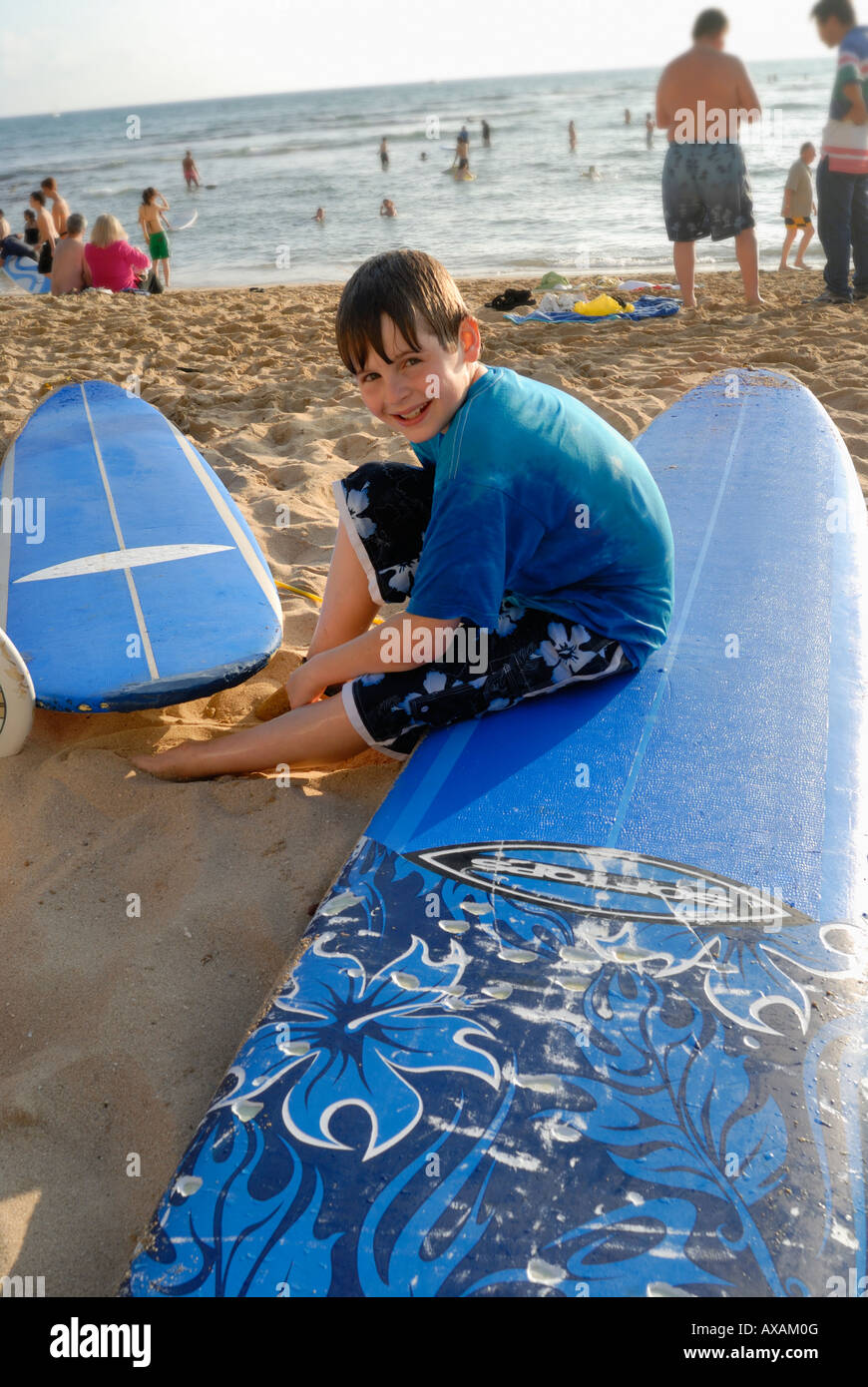 Boy age 9 12 unleashing his surfboard on Waikiki Beach after his first ...