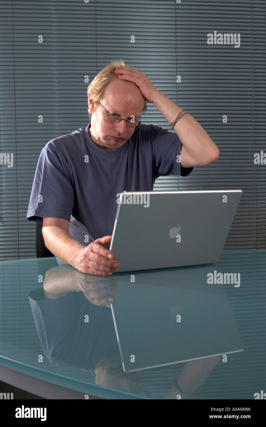 Casually dressed man sitting stressed at computer Stock Photo - Alamy