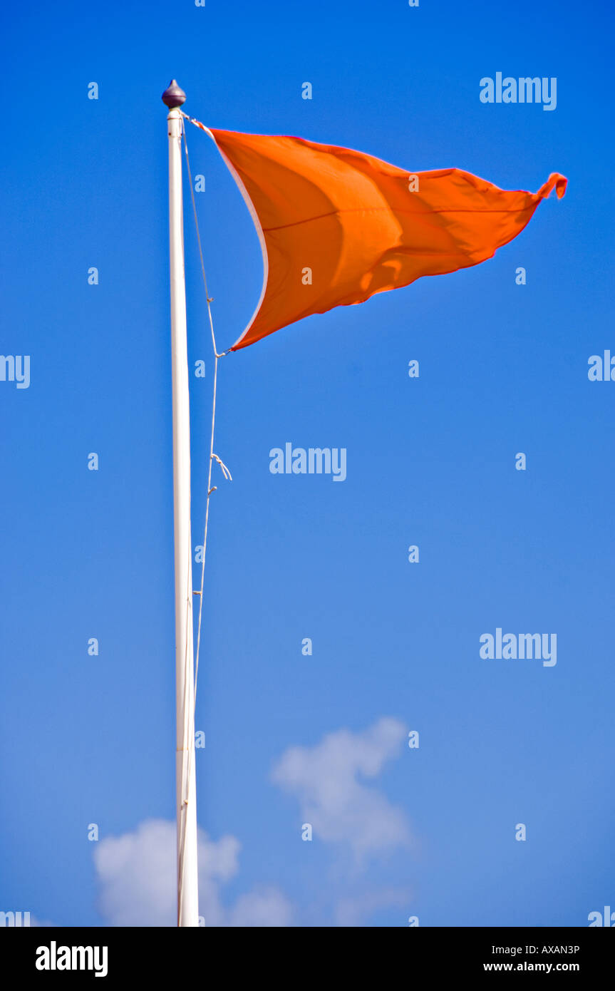 A orange warning flag flying in the wind Stock Photo - Alamy