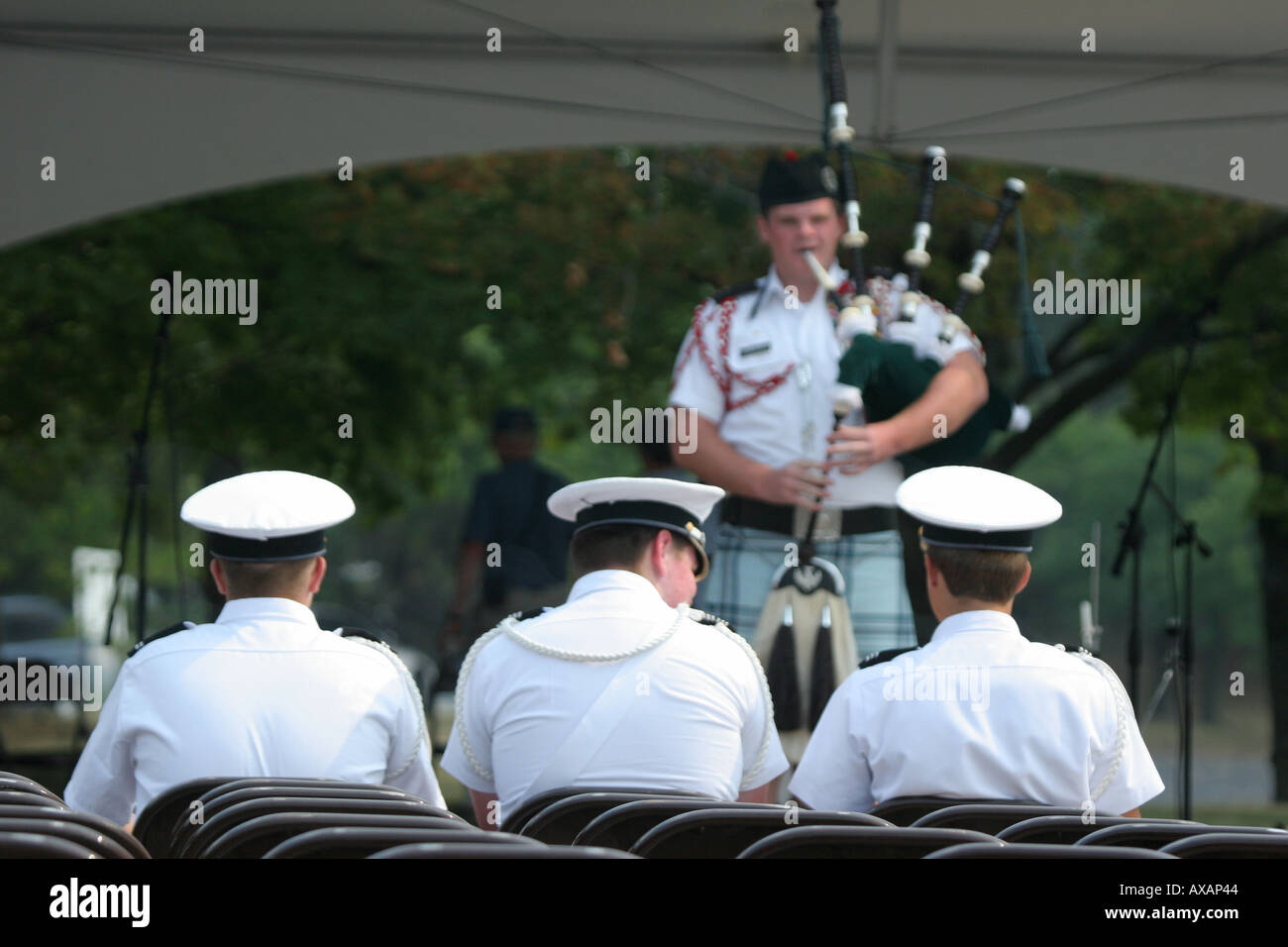 Three military uniformed men sitting in the audience listening to man ...
