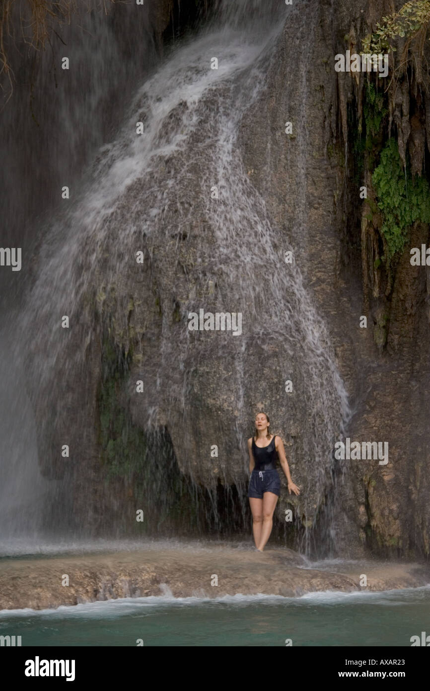 a woman stands under a waterfall Stock Photo - Alamy