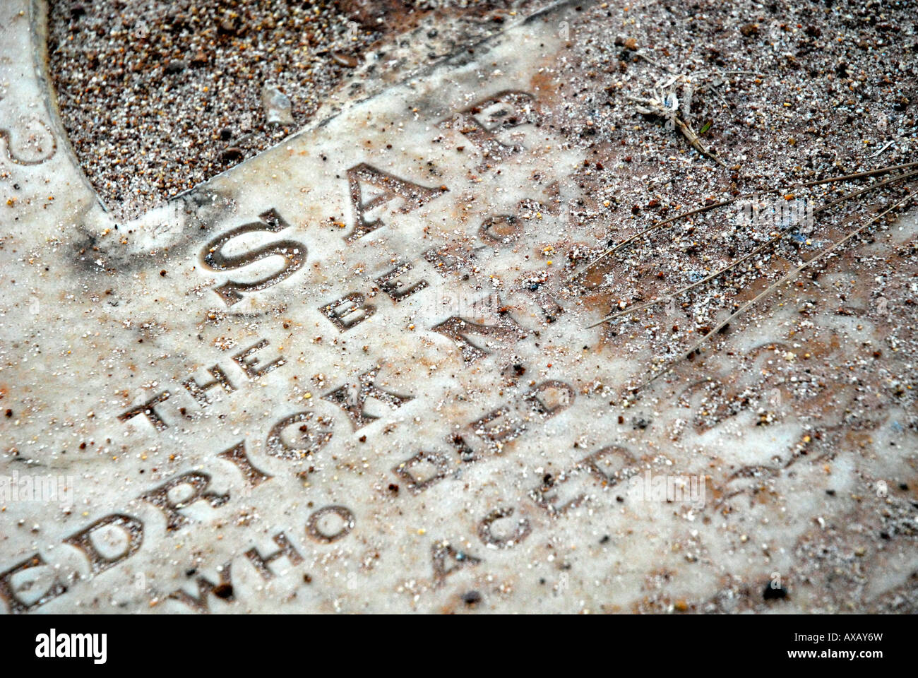 Sand cover the details on a long neglected grave stone Stock Photo - Alamy