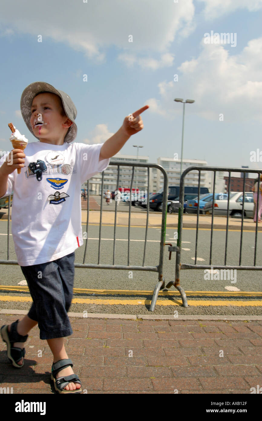 A child eating an ice-cream and pointing at something Stock Photo - Alamy