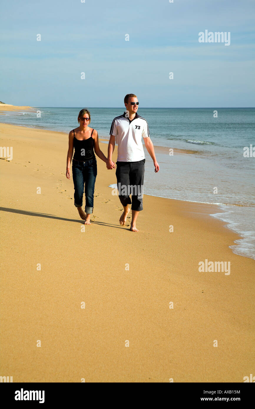 Young couple strolling together along a sandy beach Stock Photo - Alamy