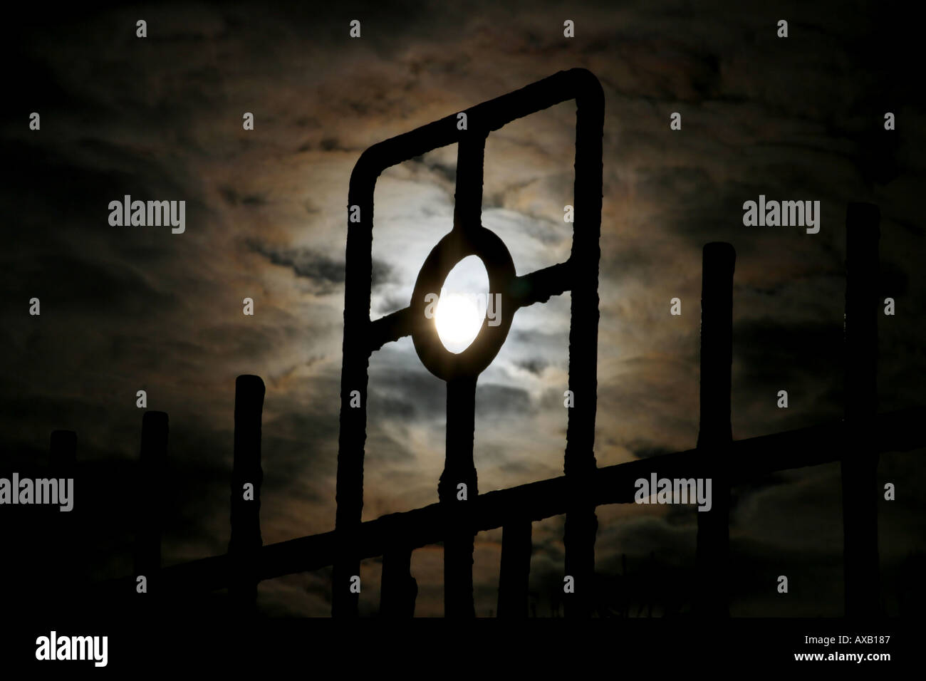 The sun shining through a graveyard fence Stock Photo - Alamy