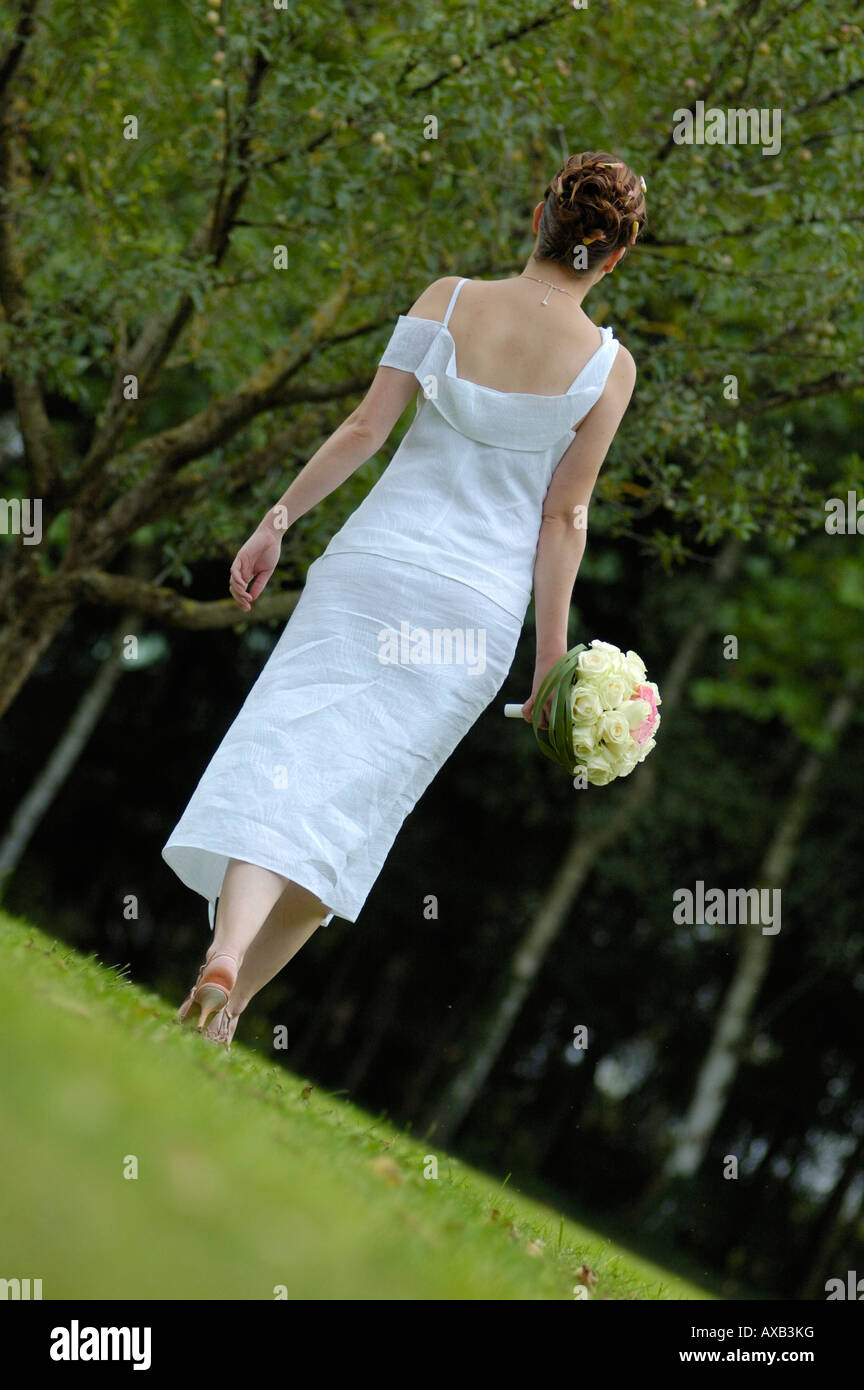 Pretty bride alone walking in park with bouquet, France Stock Photo - Alamy