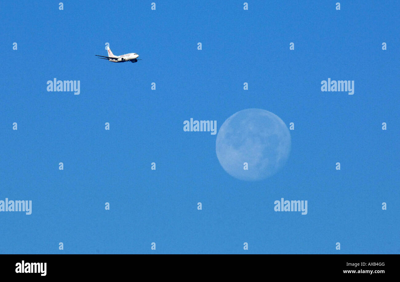 A full moon and a plane in the blue sky Stock Photo - Alamy