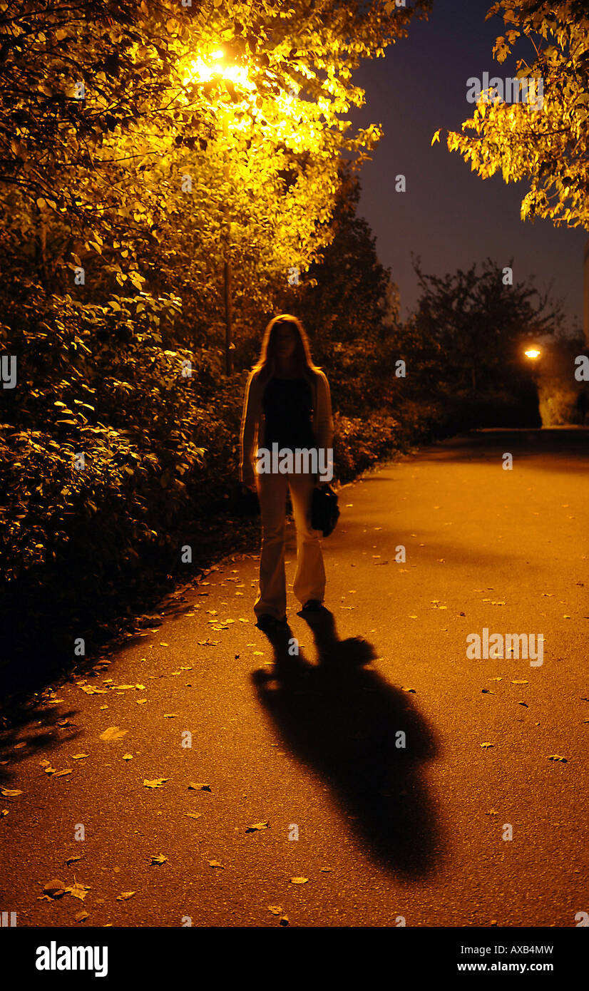 Young woman walking through the park at night Stock Photo - Alamy