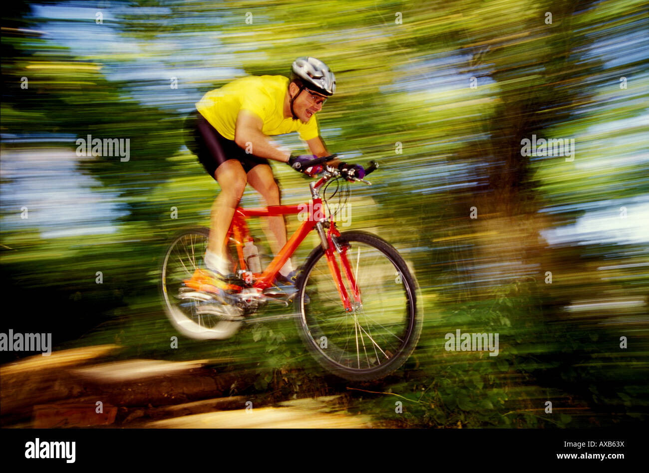 A mountain biker launches his bike off a bump and flies through the air ...