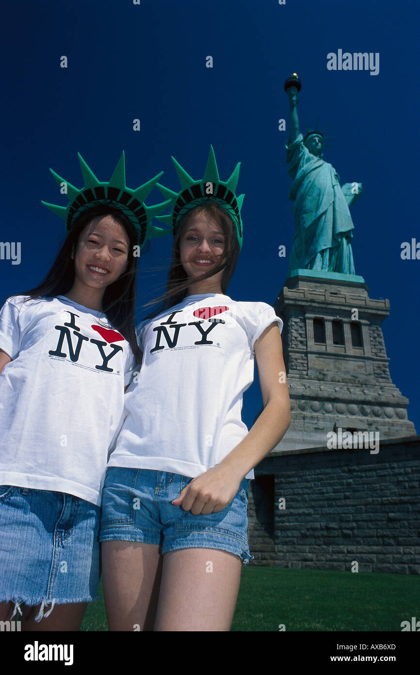 Two smiling girls in front of the Statue of Liberty, Liberty Island ...