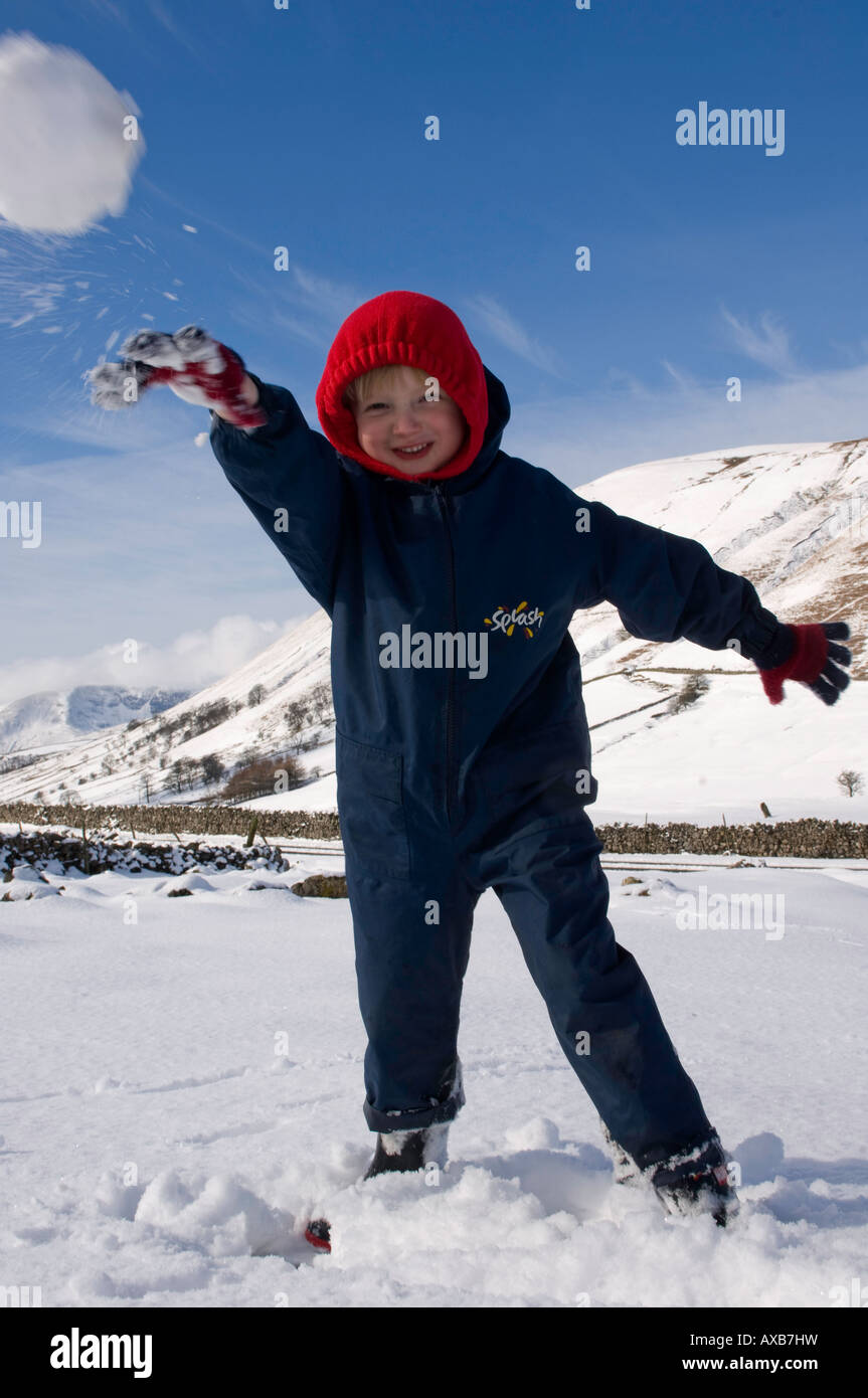 Young child in waterproof suit throwing snowball in snowy weather Stock ...