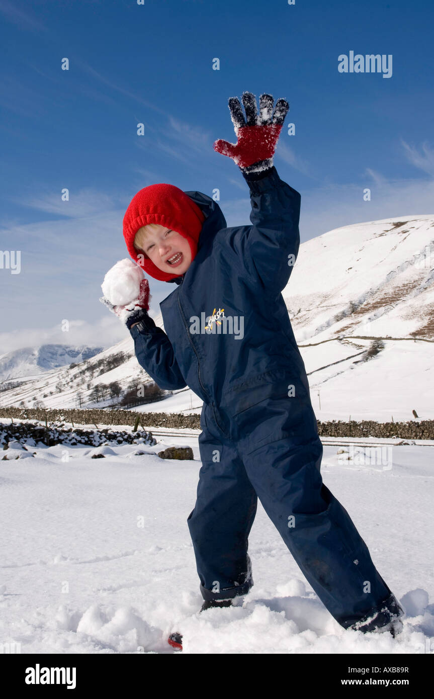 Young child in waterproof suit throwing snowball in snowy weather Stock ...