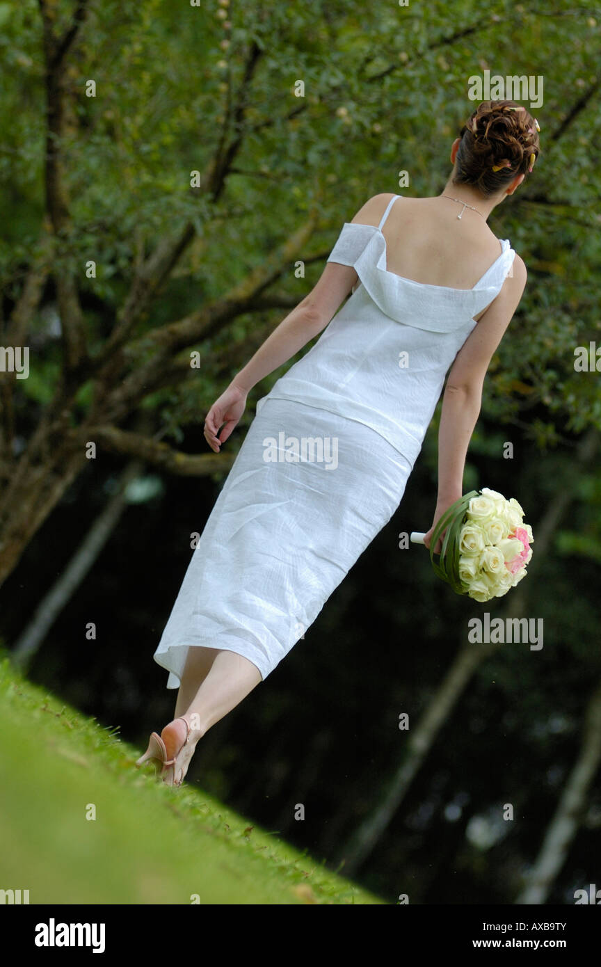 Pretty bride alone walking in park with bouquet, France Stock Photo - Alamy
