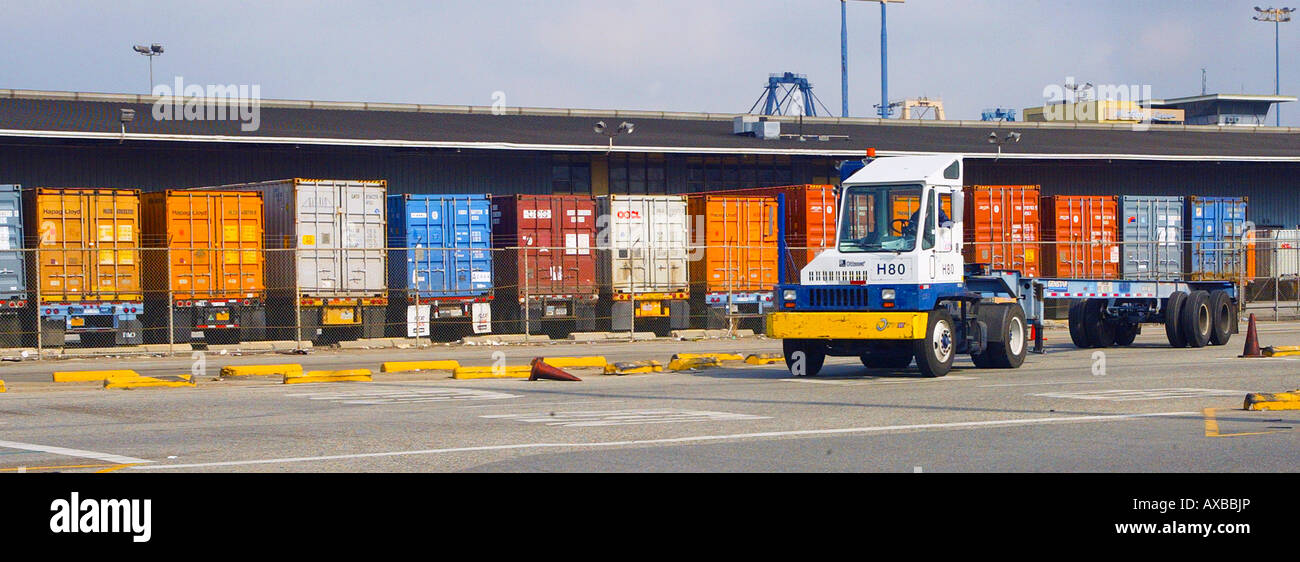 Trucks load and unload shipping containers at Los Angeles Harbor ...