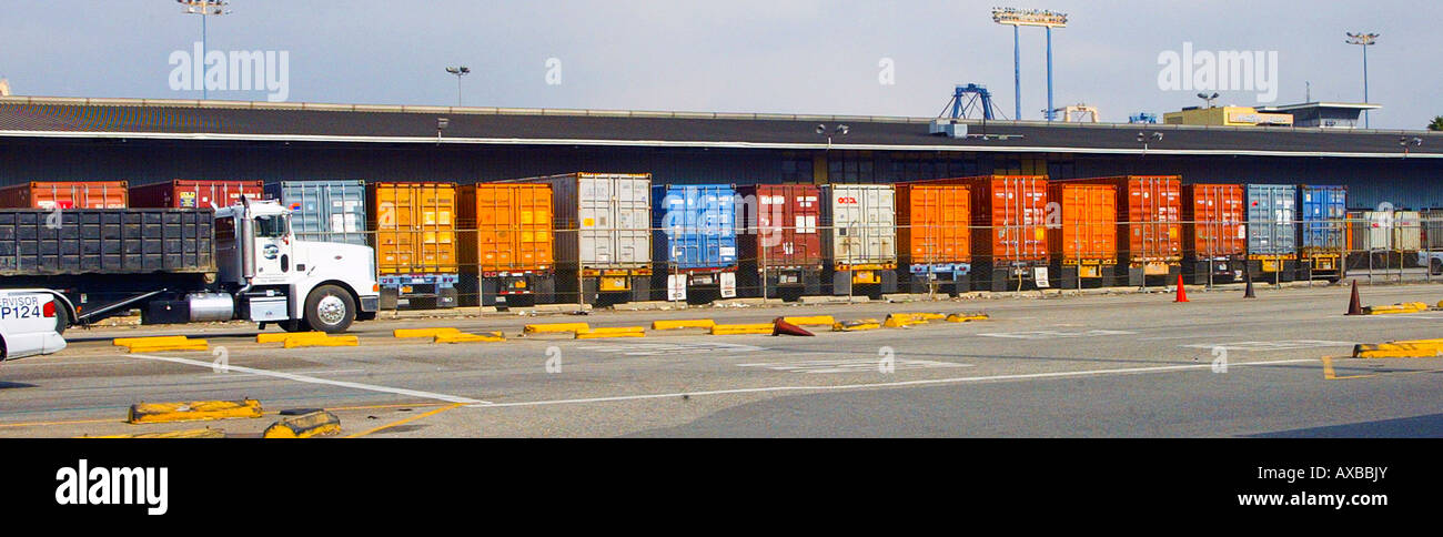 Trucks load and unload shipping containers at Los Angeles Harbor ...