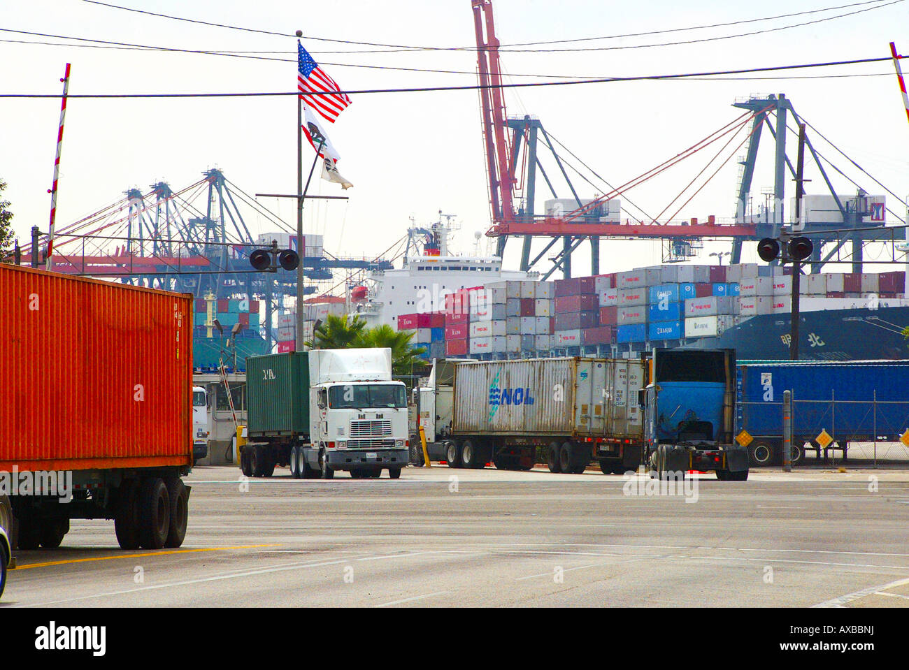 Trucks load and unload shipping containers at Los Angeles Harbor ...
