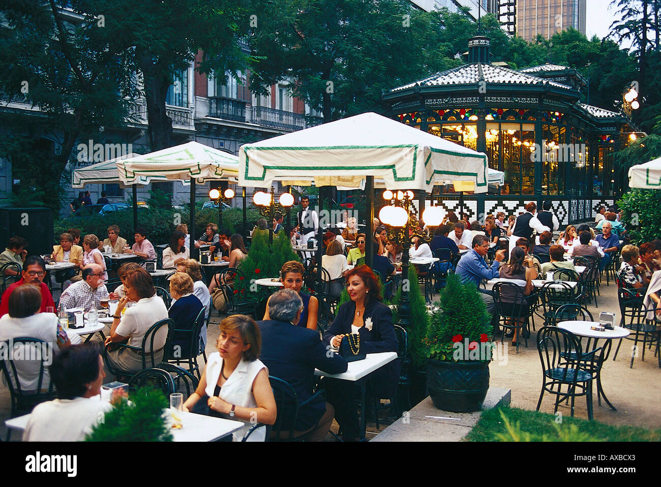 People sitting under sunshades at Café del Espejo, Paseo de Recoletos ...