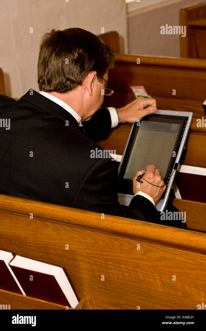 Man in a Church Pew Writing on a Computer Tablet Stock Photo - Alamy