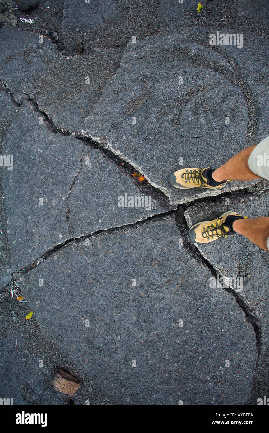 A man s feet and legs standing on an upheaval in an old lava flow in ...