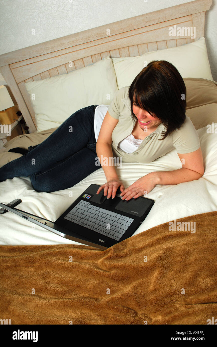 Female on Laptop Computer on Bed Stock Photo - Alamy