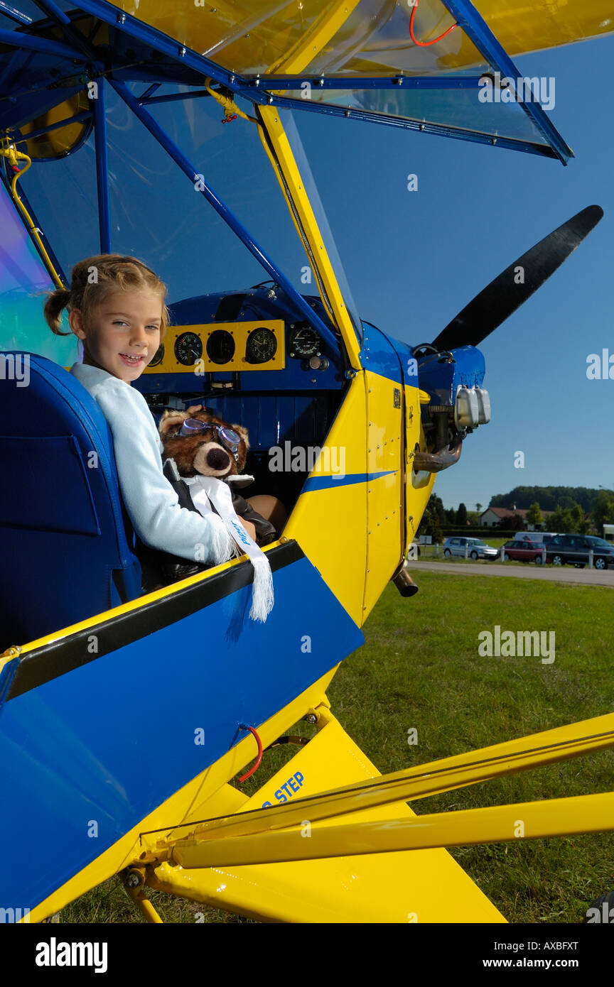 Young girl with her teddy bear pilot in the cockpit of the famous Piper ...