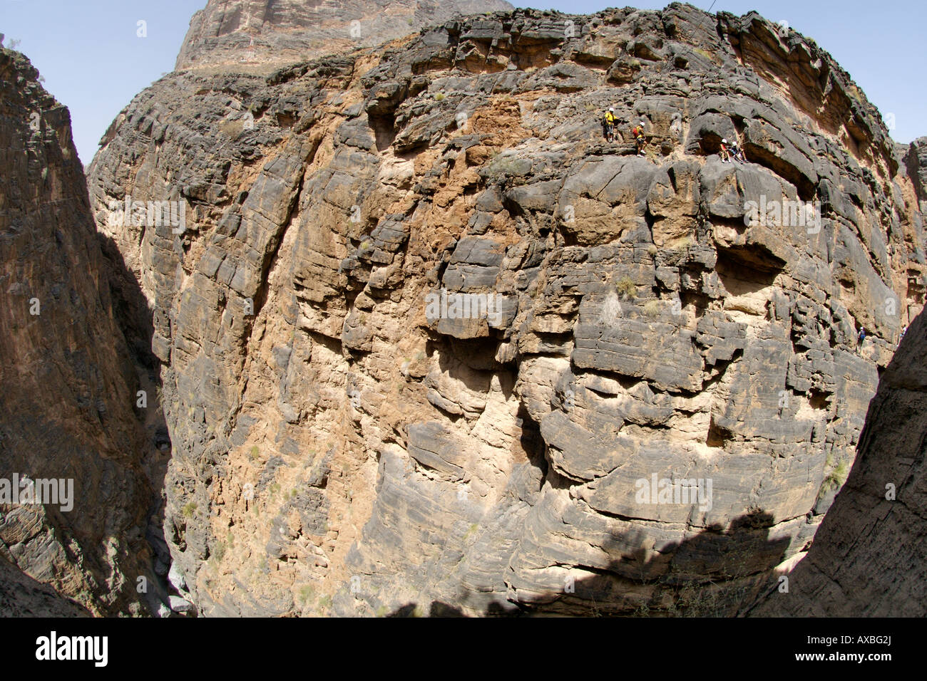 Four rock climbers dwarfed by the cliffs of Snake Canyon in Jebel ...